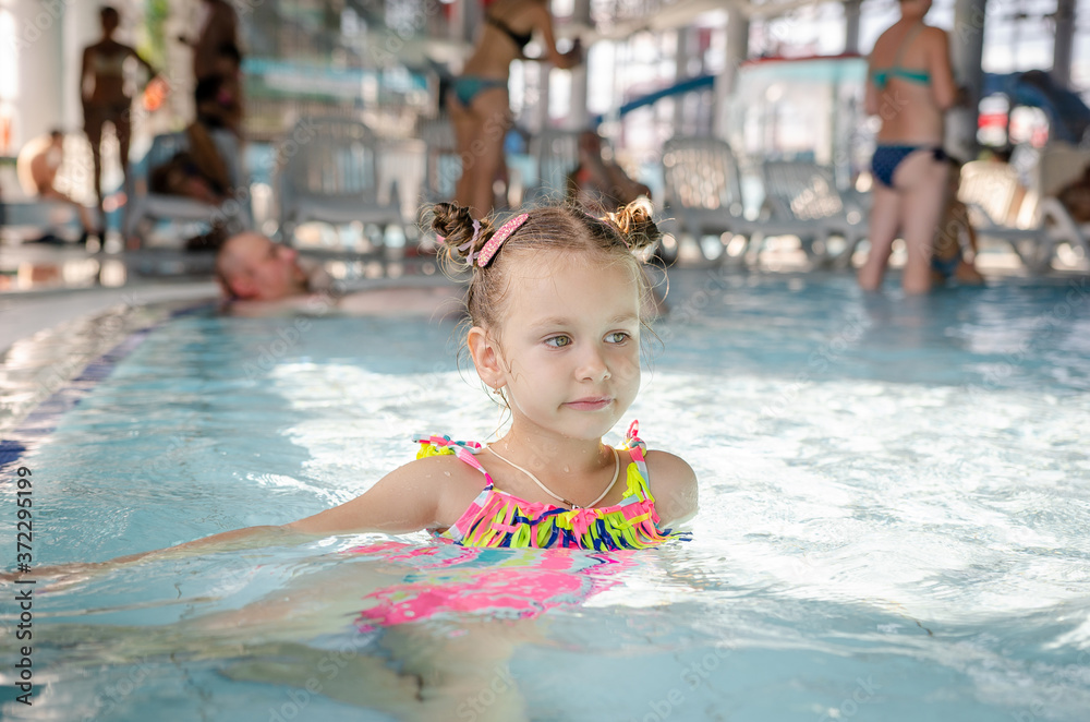 Foto de little beautiful girl playing with a foam noodle in a indoor ...