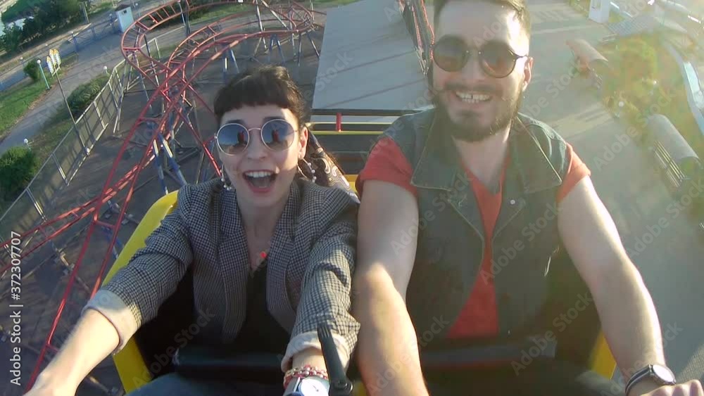 Selfie video of couple riding the roller coaster. Hipster man and ...