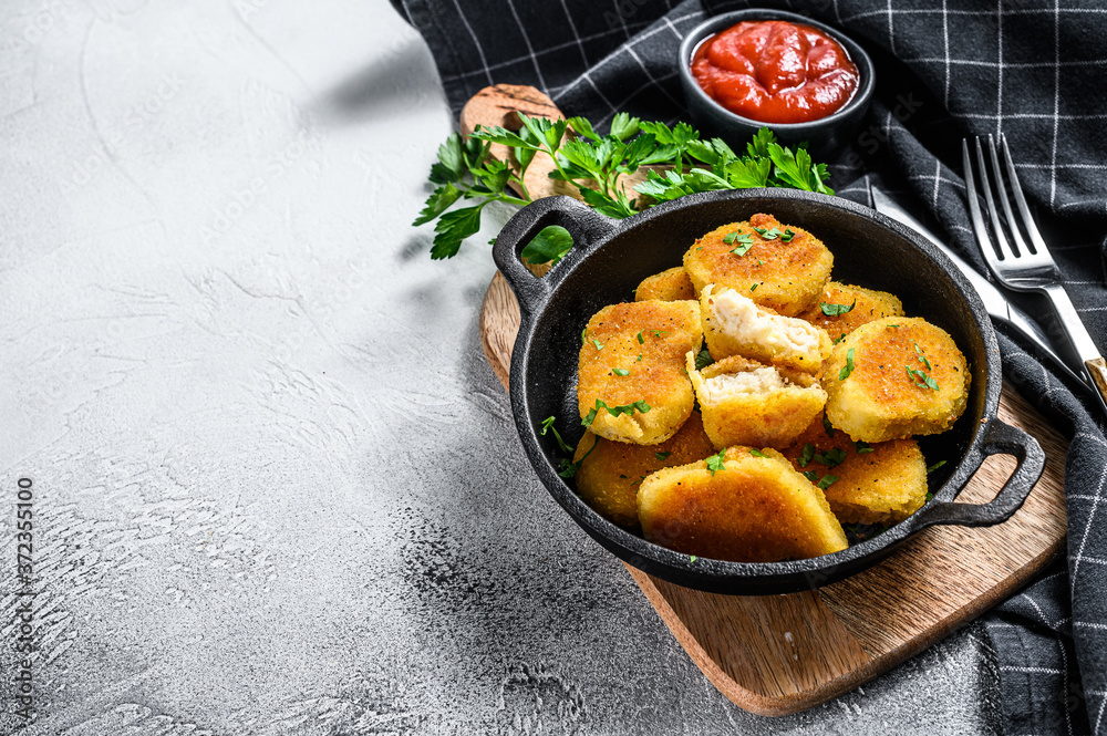 Crispy fried chicken nuggets in a pan with ketchup and herbs. White ...