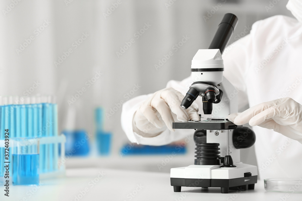 Scientist using microscope in laboratory Stock Photo | Adobe Stock