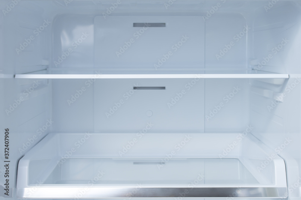 Shelves in empty open white fridge. Background empty shelves in the ...