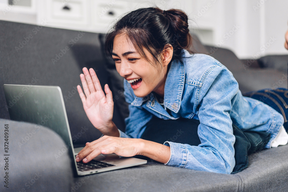 Young smiling happy beautiful asian woman relaxing using laptop ...
