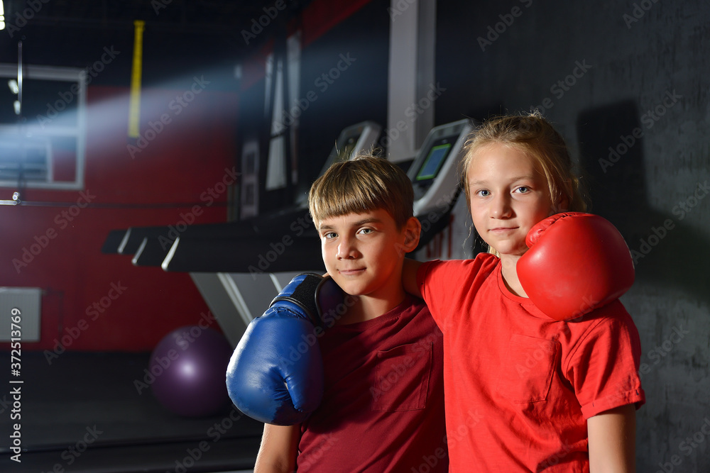 Brother and sister in boxing gloves are hugging each other. Children ...