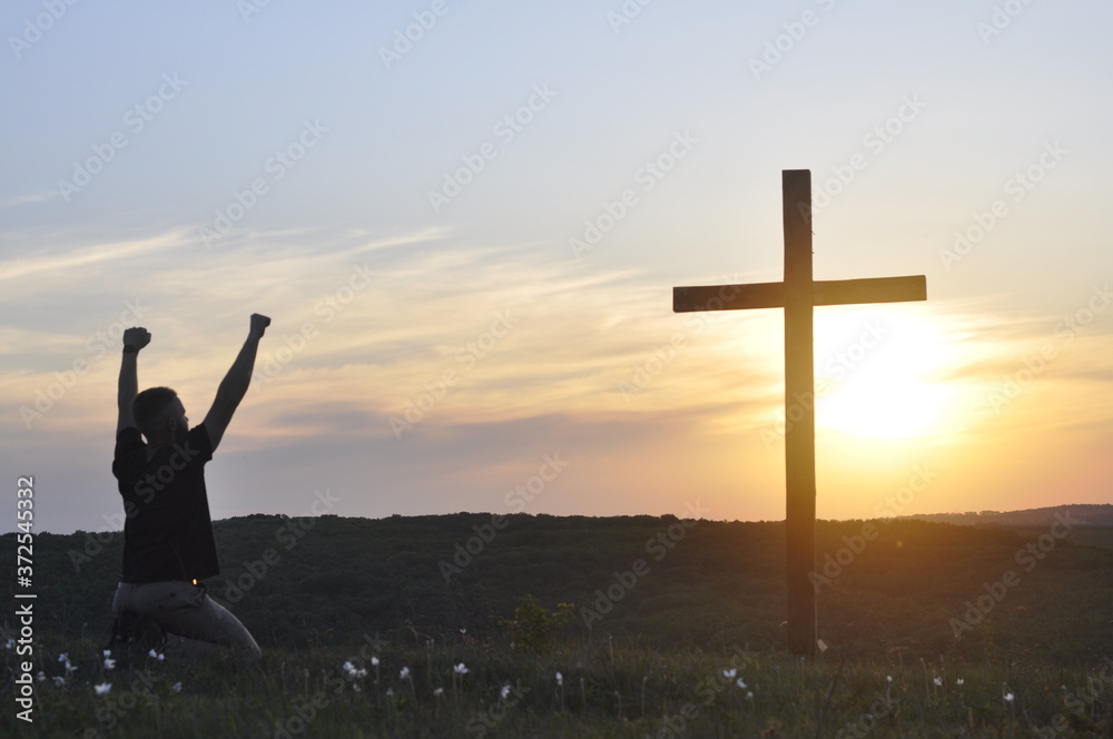 Cross. Young man on his knees. Prayer and worship to God. The cross of ...