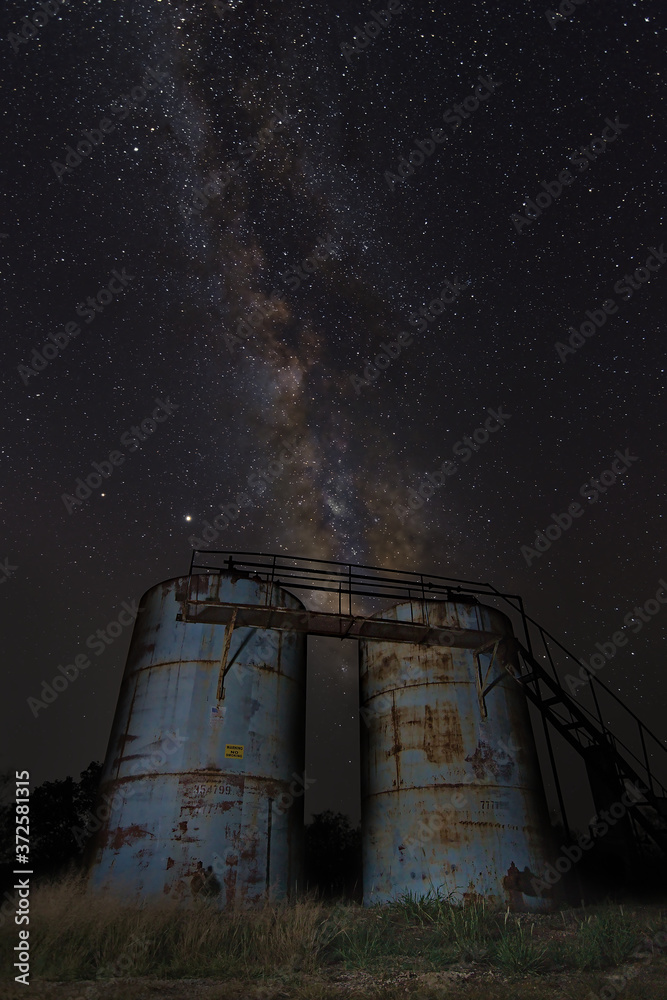 Galactic core milky way rises behind two unused water storage tanks in ...