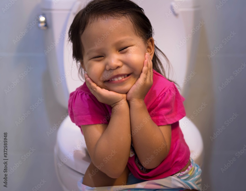 Happy little girl sitting on the toilet. Potty training. Stock Photo ...