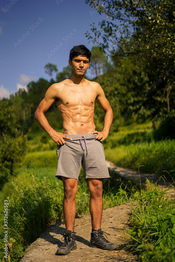 Young shredded boy standing shirtless on the pathway. Fitness and ...