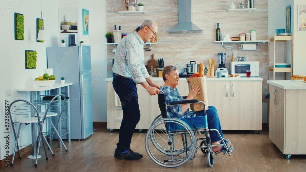 Vidéo Stock Husband pushing invalid senior woman in wheelchair with ...