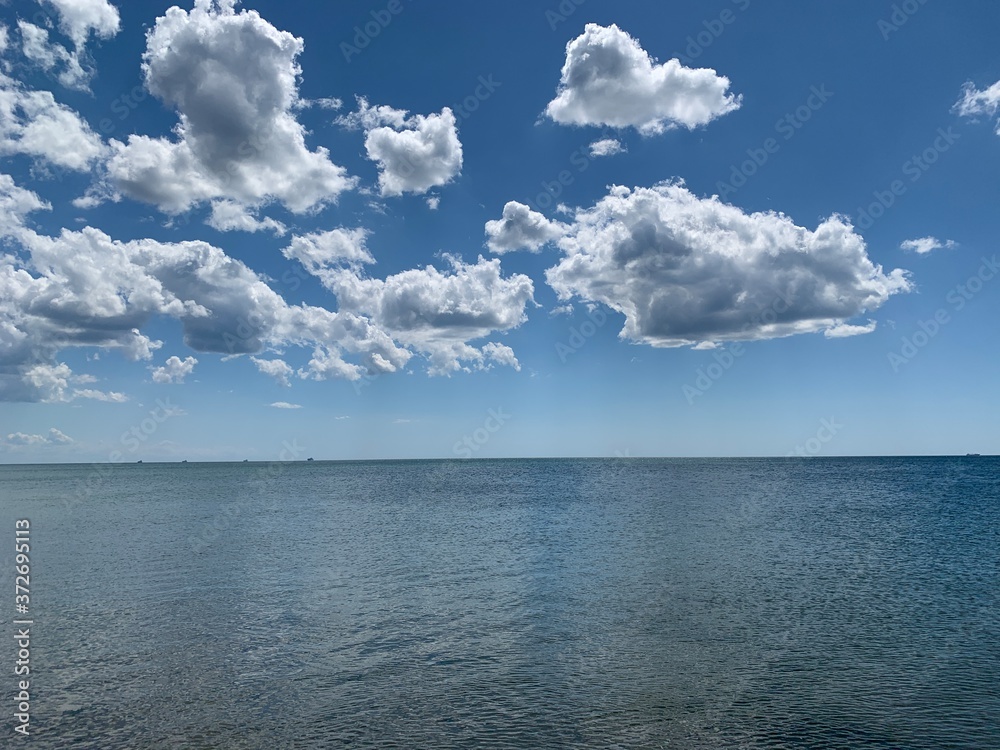 Blue beautiful sky and white clouds over the ocean. Clear weather ...