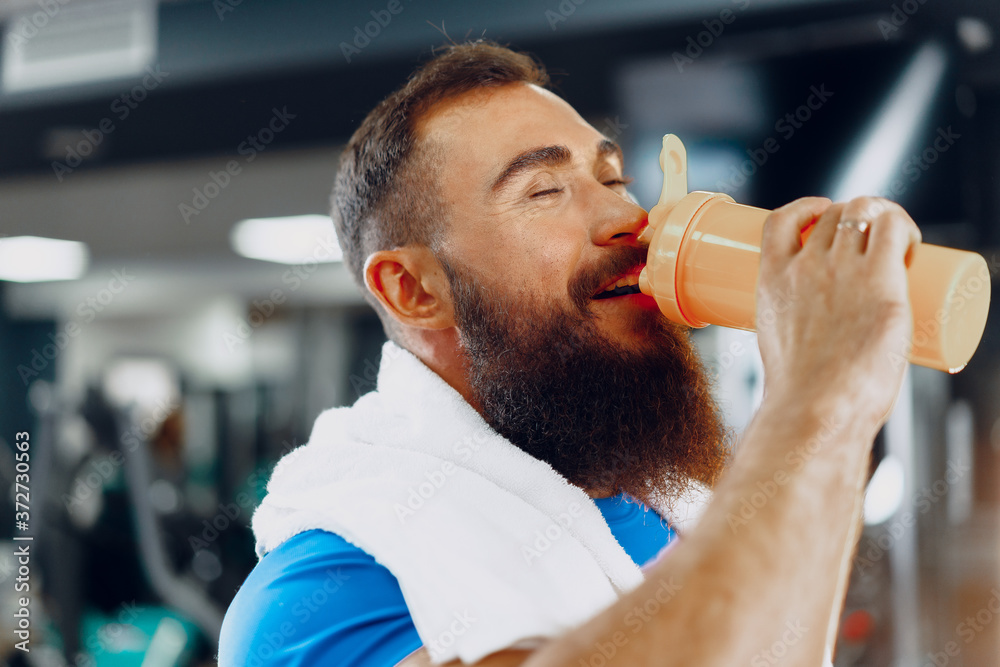 Bearded man bodybuilder having a drink after workout in a gym Stock ...