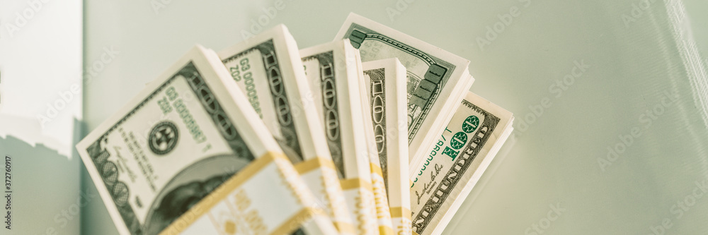 Cash wads lying on white background banner. Panoramic of stacks of us ...