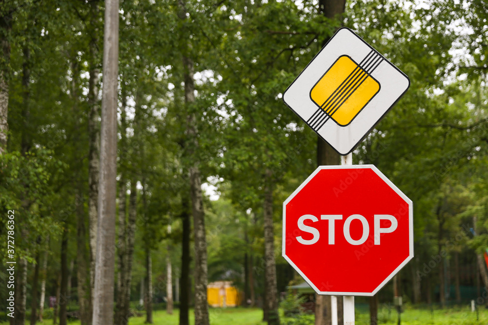Foto de traffic sign "stop" and "end of main road" in front of an ...