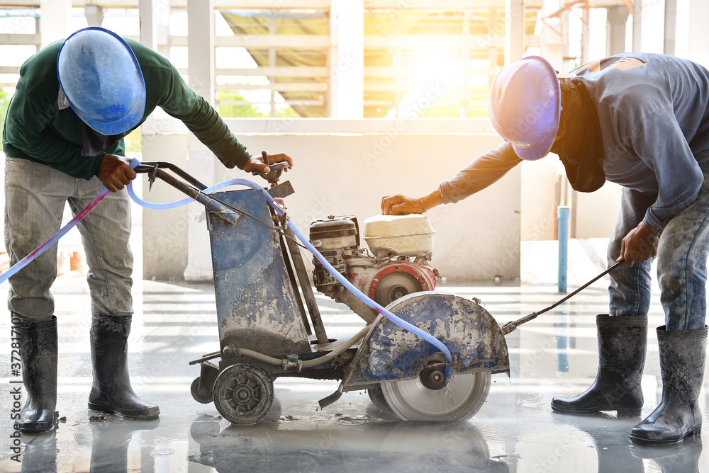 Foto Stock Workers using cutting machine are cutting concrete for ...