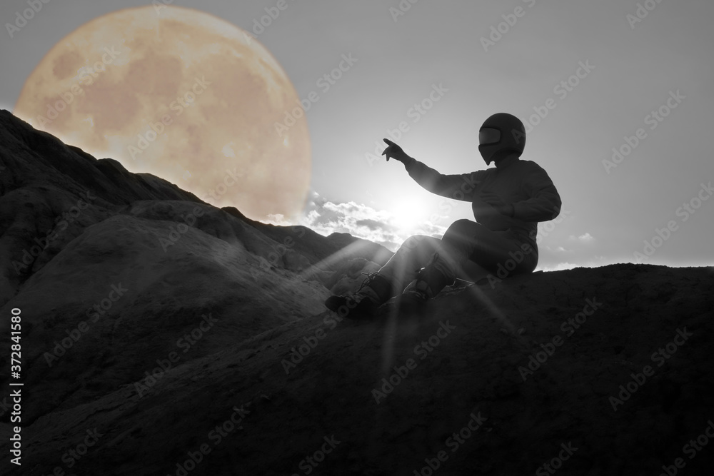 spaceman pointing at beautiful sky with stars while sitting on top of ...