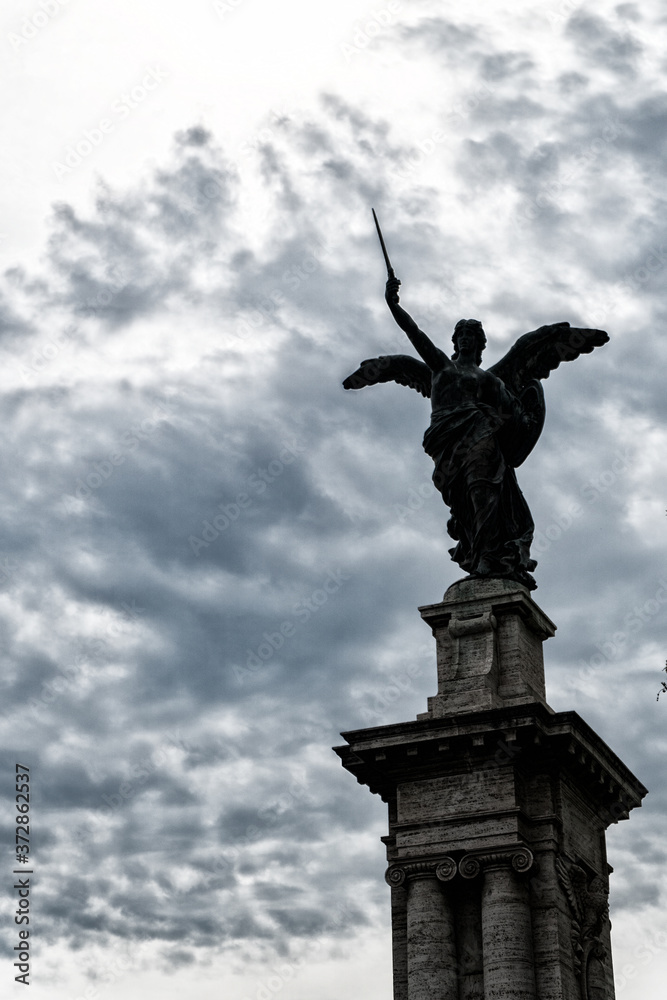 Statue of an angel in Rome with sword and clouds background with sun ...
