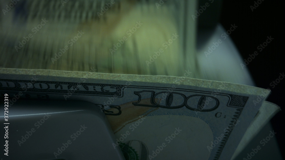 Counter counting dollar bills. Money counting machine with 100 dollar ...