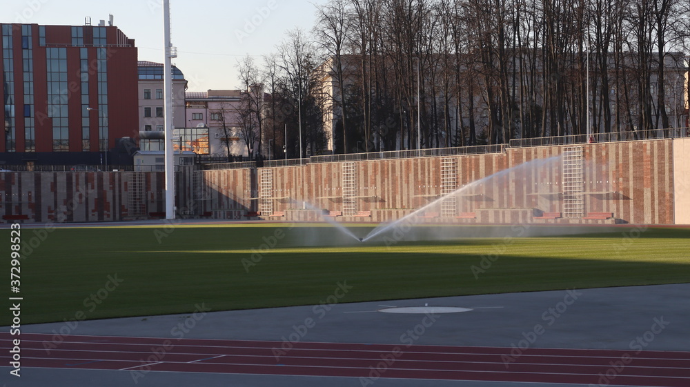green football pitch and watering the lawn process Stock Photo | Adobe ...