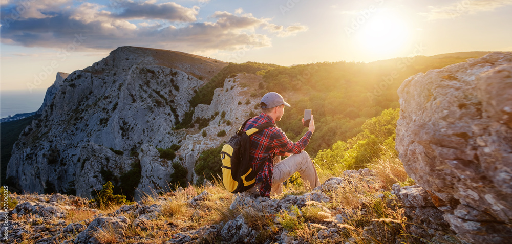 Strong man hiker taking photo with smart phone at mountain peak. Stock ...