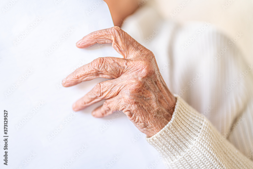 Nahaufnahme Hand, alte Frau mit faltigen Händen liest einen weißen ...