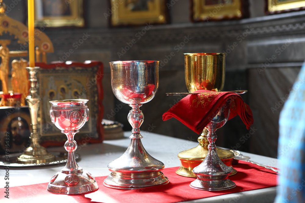 Metal, silver and gold bowls for communion, covered with red cloth on ...