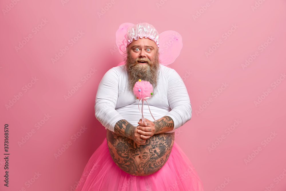 Horizontal shot of bearded fatso man foolishes around on childrens ...