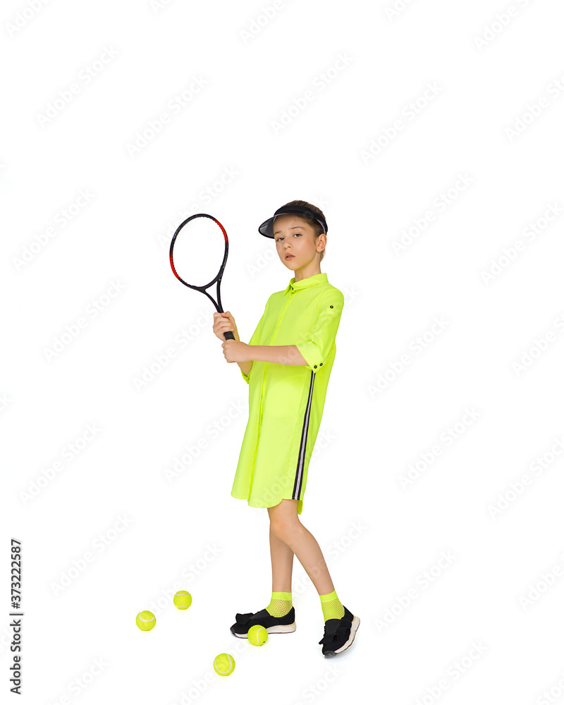 A beautiful 12-year-old girl in bright sports clothes, a tennis racket ...
