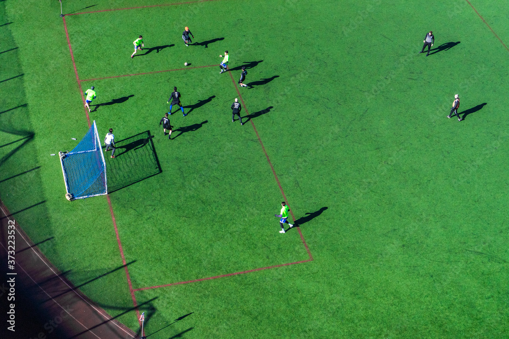 View from above of people playing soccer on a green football field in ...