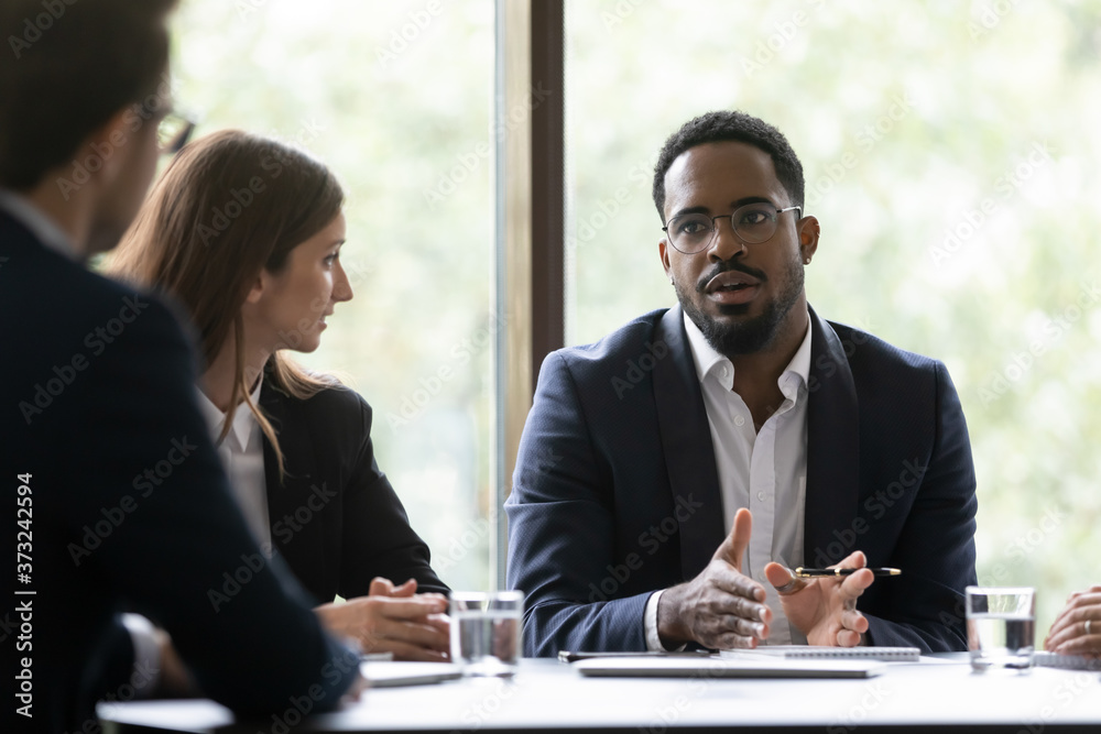 Concentrated black team leader posing problem to employees, afro ...