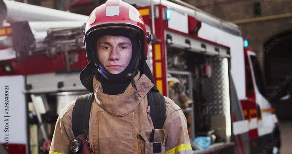 Middle plan of caucasian handsome fireman in helmet and gull equipment ...