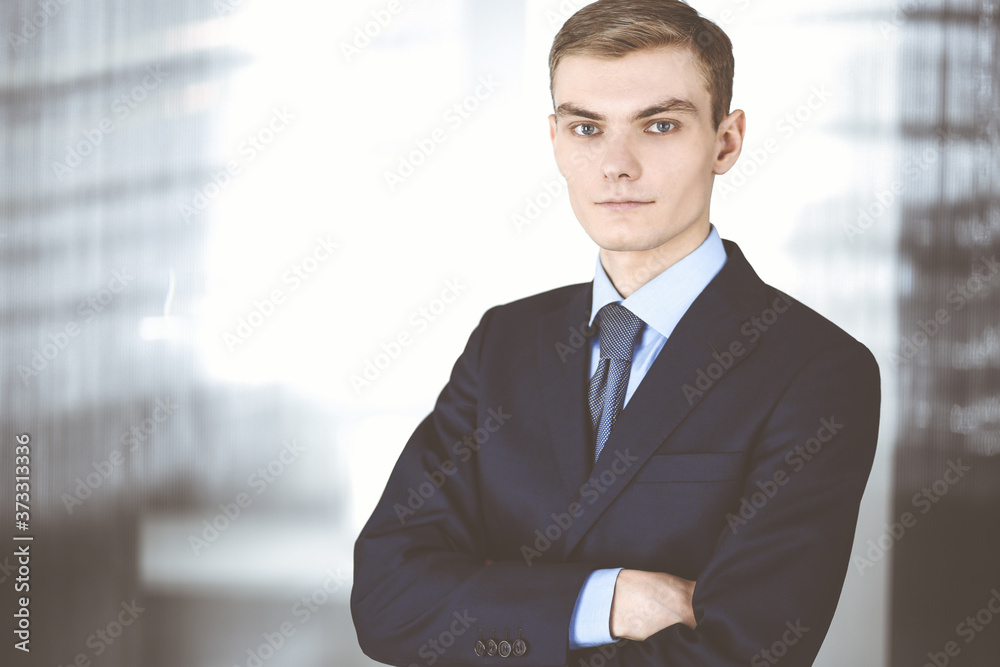 Foto de Young businessman wearing suit and tie, while standing in the ...