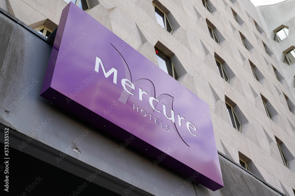 mercure hotel sign text and purple logo on building entrance facade ...
