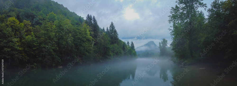 Scary spooky river of Kolpa on a gray dull summer day with clouds and ...