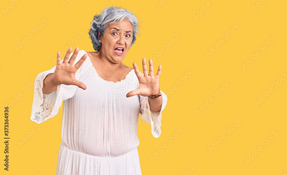 Senior woman with gray hair wearing bohemian style afraid and terrified ...