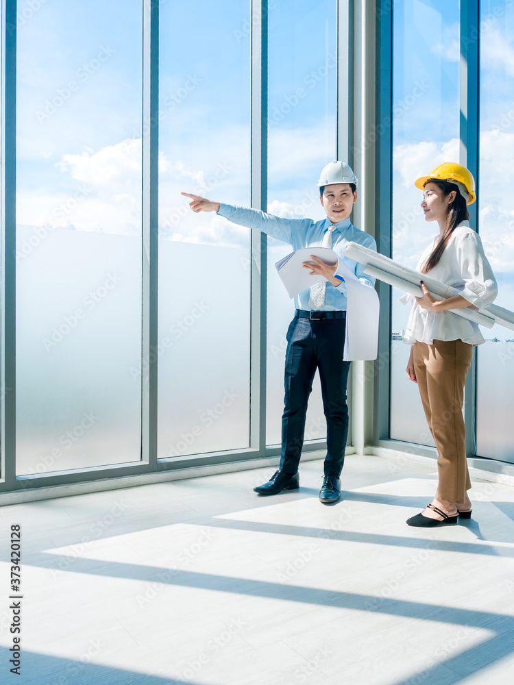 Asian architect Male and female inspecting construction work inside ...