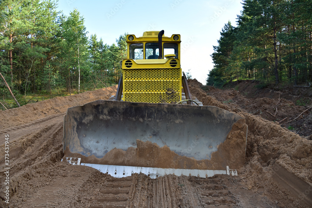 Dozer during clearing forest for construction new road . Yellow ...