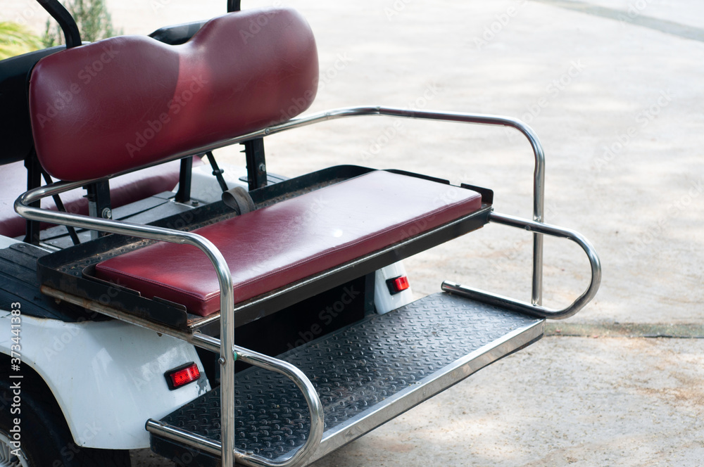 Back of golf cart with dark red leather seat, electric power vehicle ...