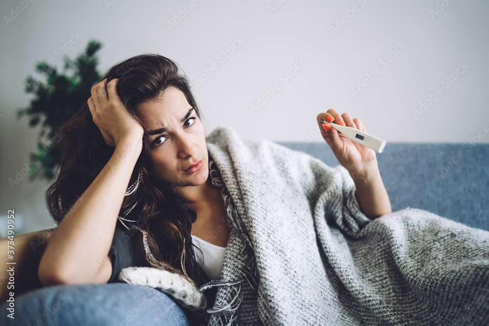Tired caucasian female exhausted with virus disease lying on sofa ...