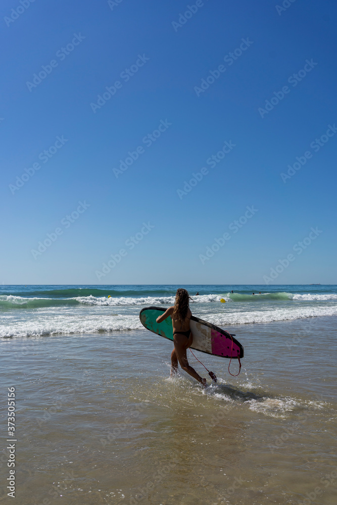 Chica joven y guapa surfeando por playas de Cadiz Stock Photo | Adobe Stock