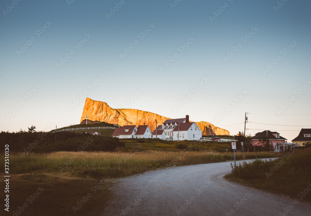 Prominent Percé Rock towers over the coastal homes Stock Photo | Adobe ...