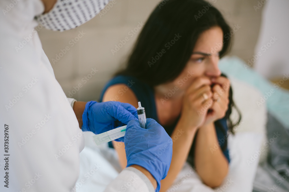 The female doctor in protective equipment a mask, gloves performs the ...