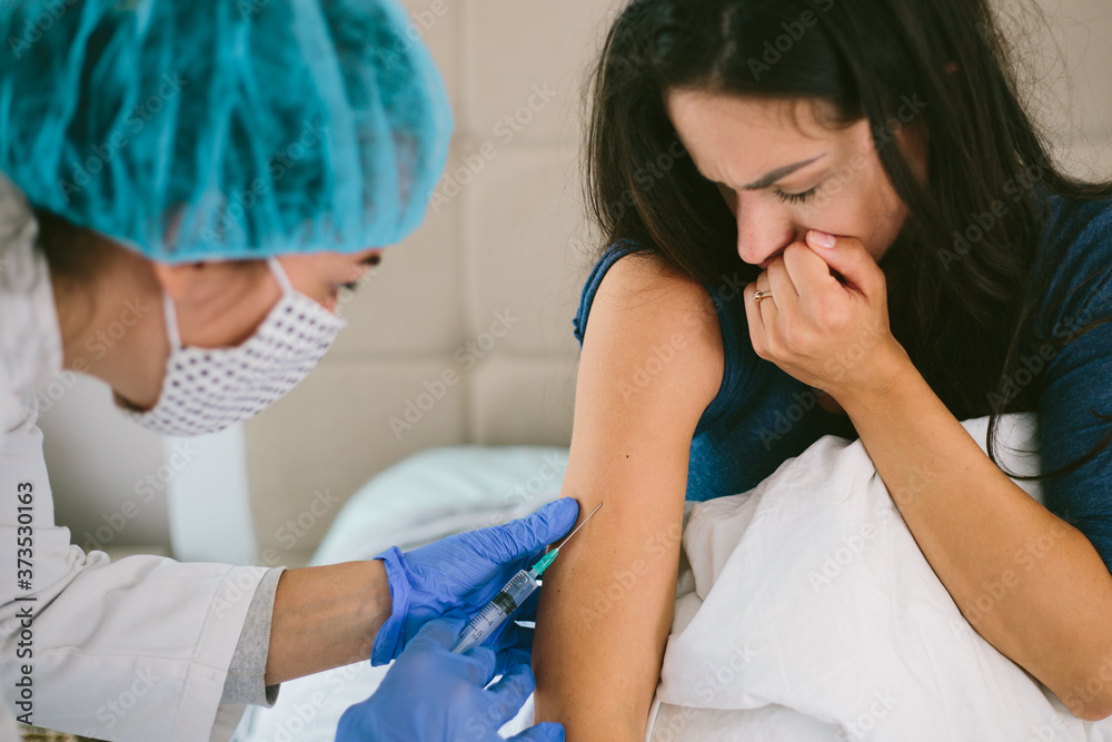 The female doctor in protective equipment a mask, gloves performs the ...