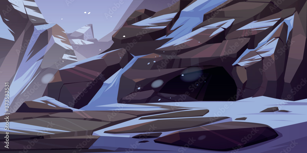 Entrance to cave in mountain with ice and snow on rocks around. Grotto ...