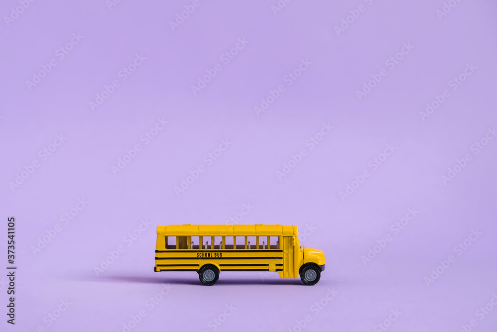 Back to school concept. Traditional yellow school bus on purple ...