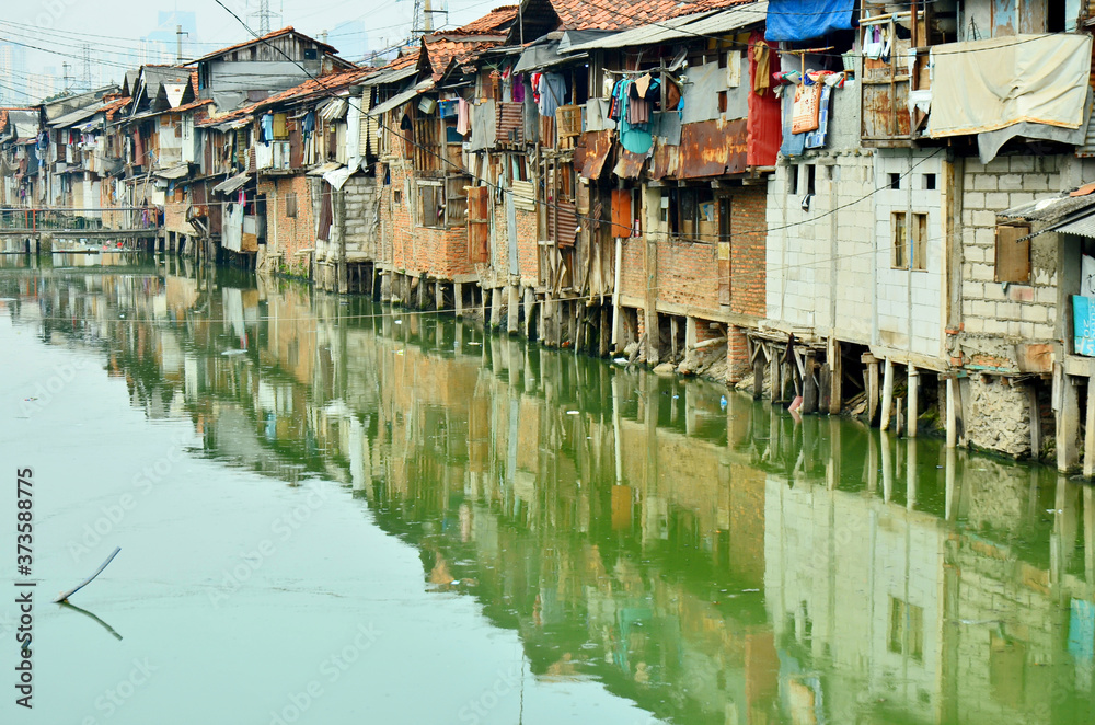 Slum house on the edge of a canal in Jakarta Stock Photo | Adobe Stock