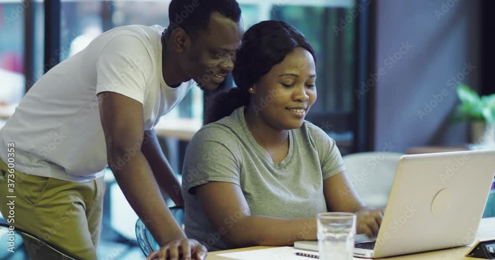 Happy African couple celebrate good job people working together using ...