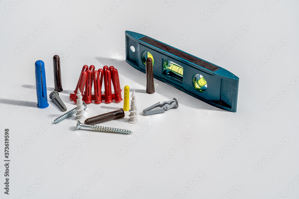 Small spirit level, wall anchors plugs and screws for a DIY project in ...