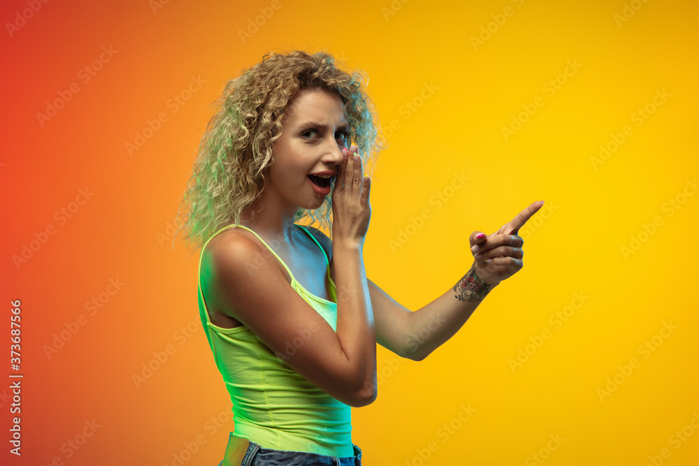 Pointing, showing. Caucasian young woman's portrait isolated on ...