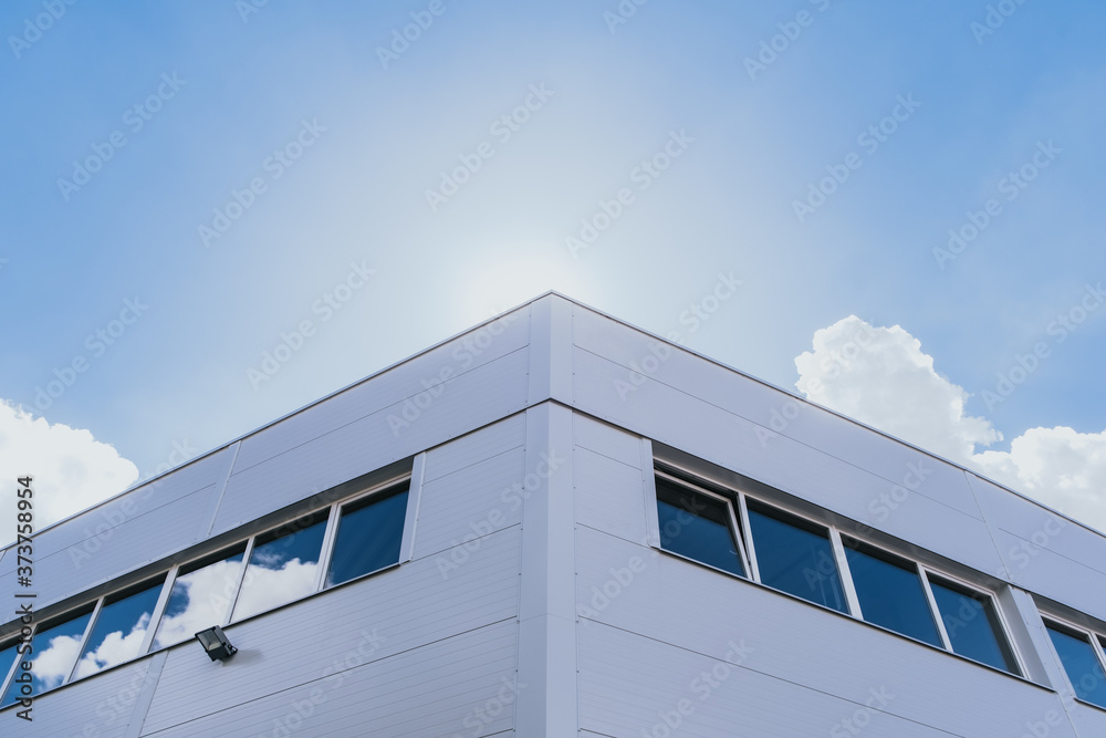 Modern corner of a white warehouse with sheet metal cladding and ...