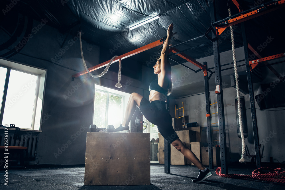 Stretching. Young caucasian female athlete training in gym, doing ...