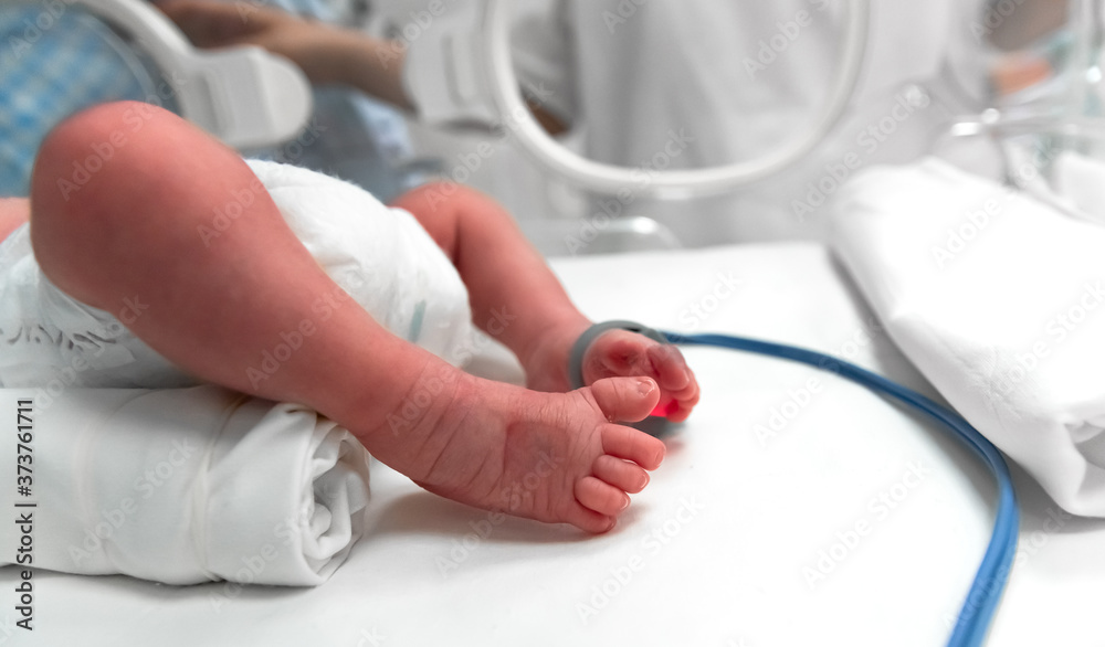 Premature baby feet with a neonatal pulse oximetry monitor, selective ...